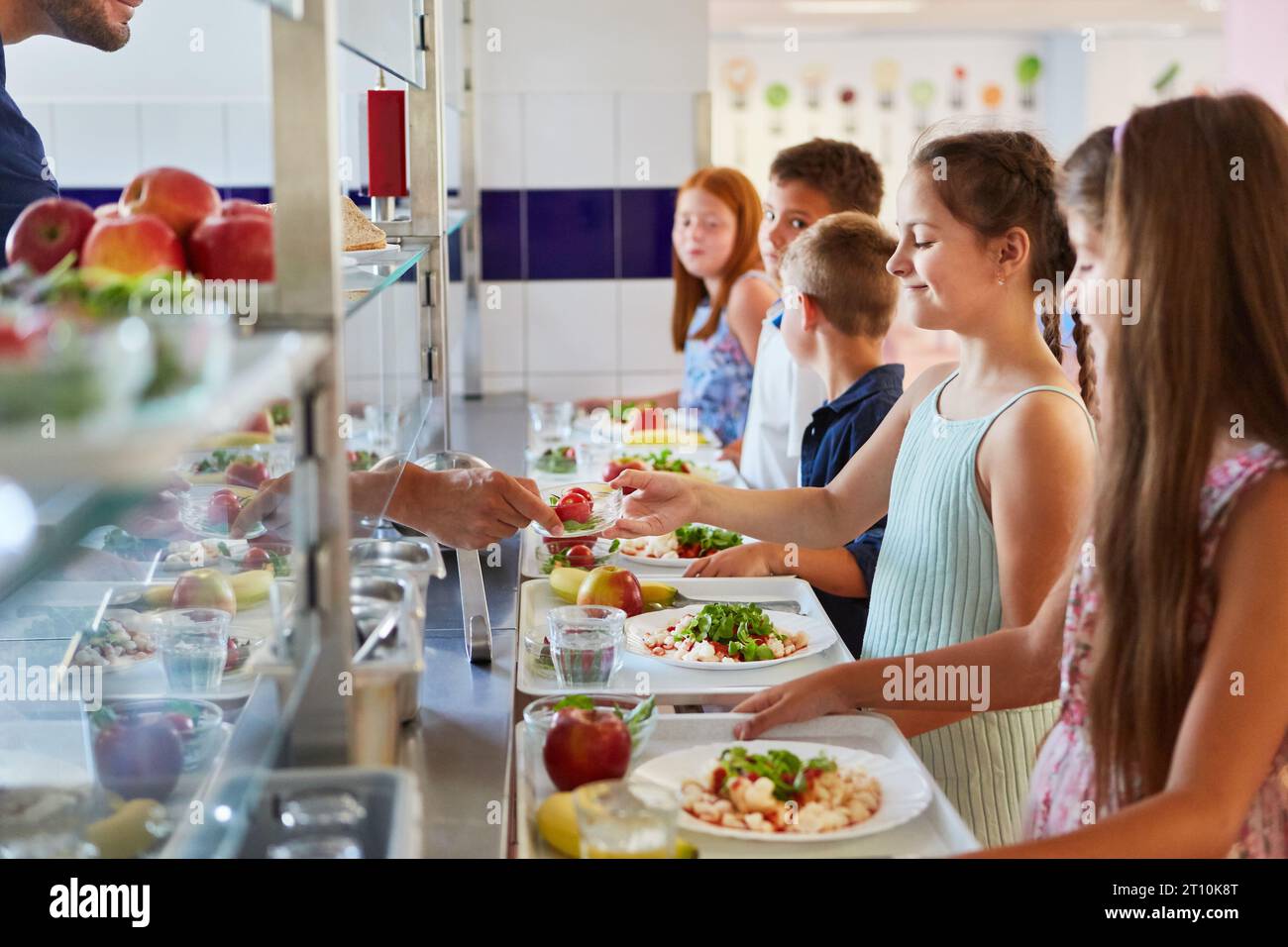 Group of children as elementary students at buffet line, enjoying ...