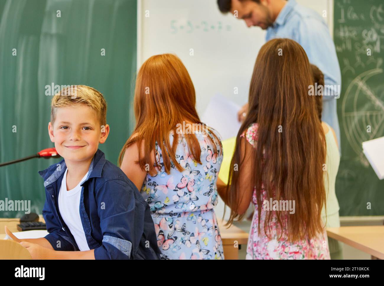 Portrait of smiling boy with friends during lecture in classroom Stock ...