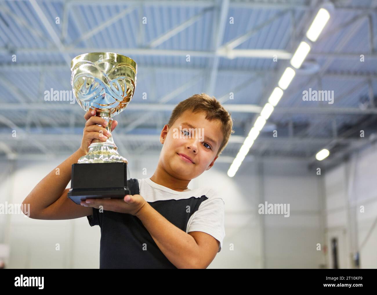 Portrait of schoolboy holding trophy in school gym Stock Photo - Alamy