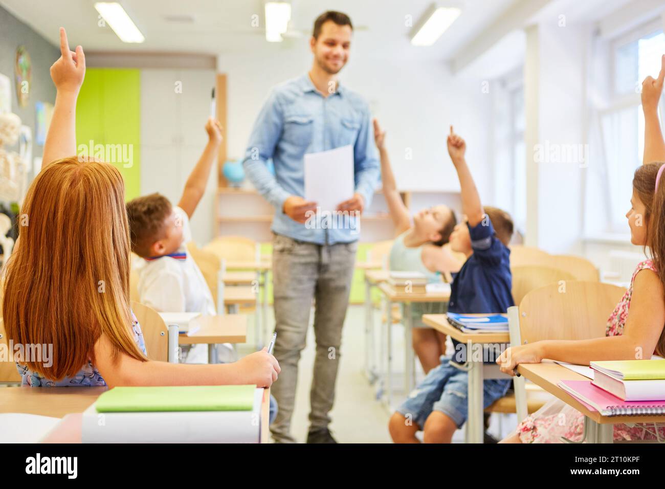Male and female pupils answering while sitting during lecture in ...