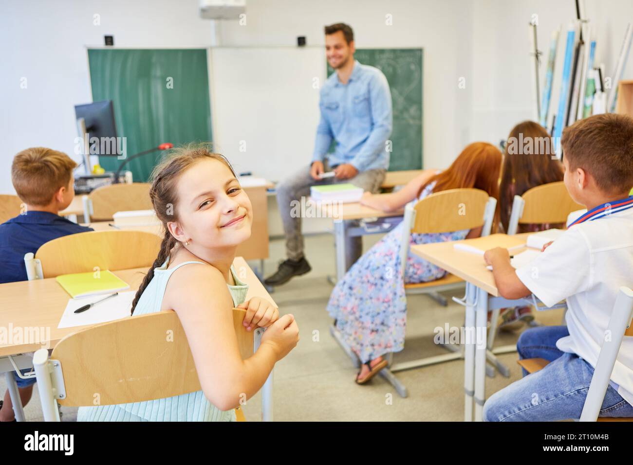 Portrait of smiling female student looking over shoulder while sitting ...