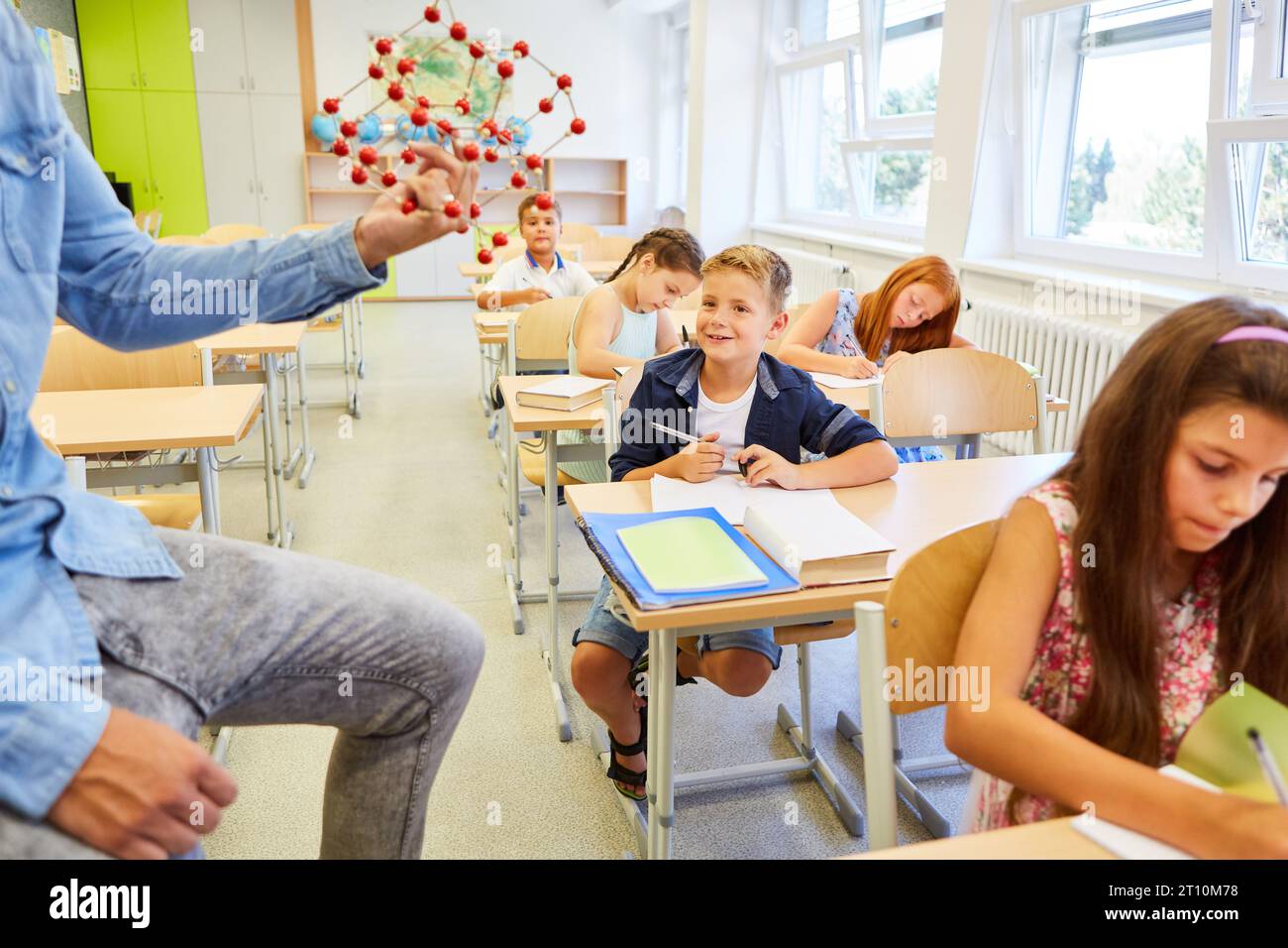 Teacher explaining elementary students through molecular structure in ...
