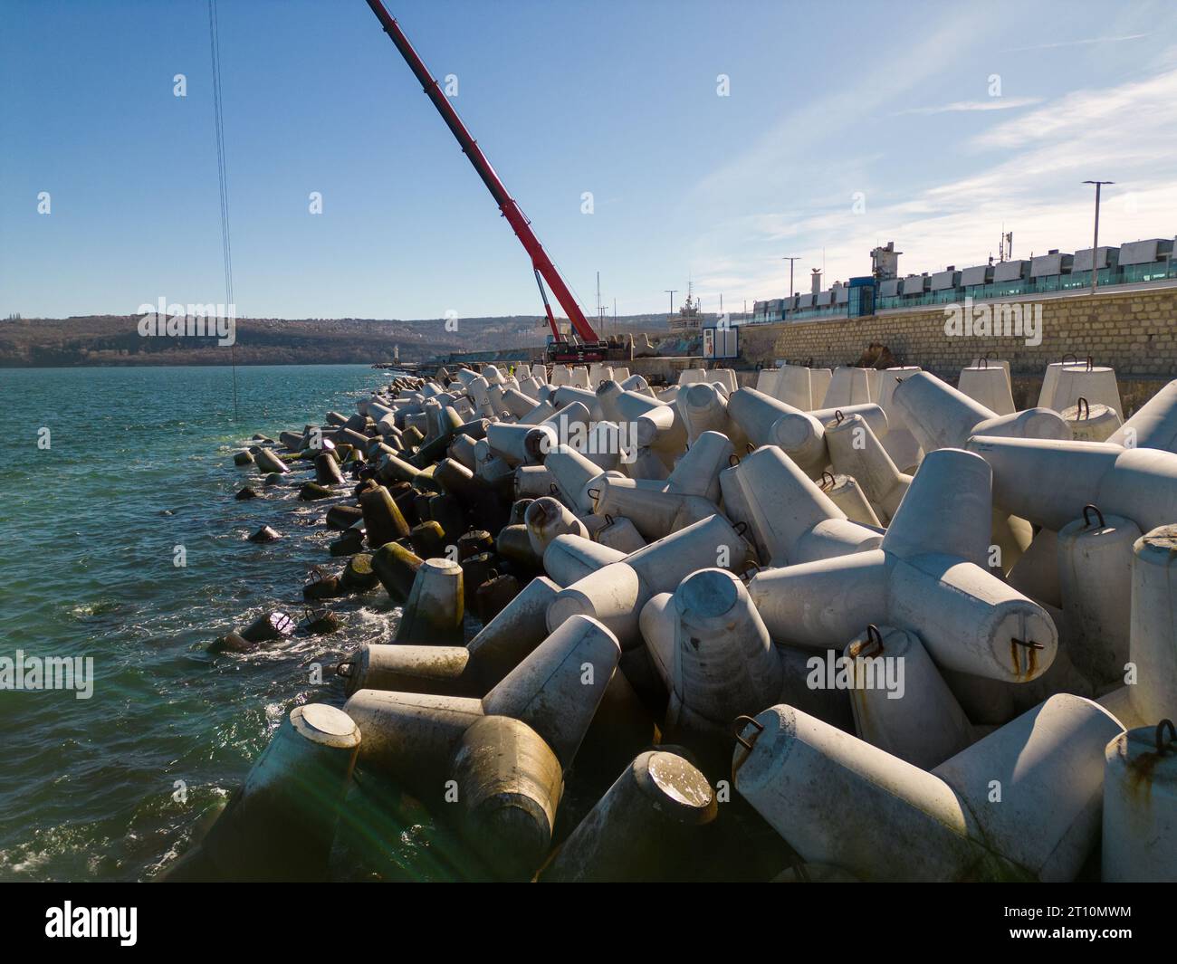 Aerial top view of breakwater construction. Bulldozer and crane on a ...