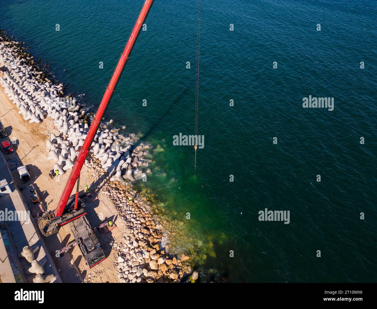 Aerial top view of breakwater construction. Bulldozer and crane on a ...