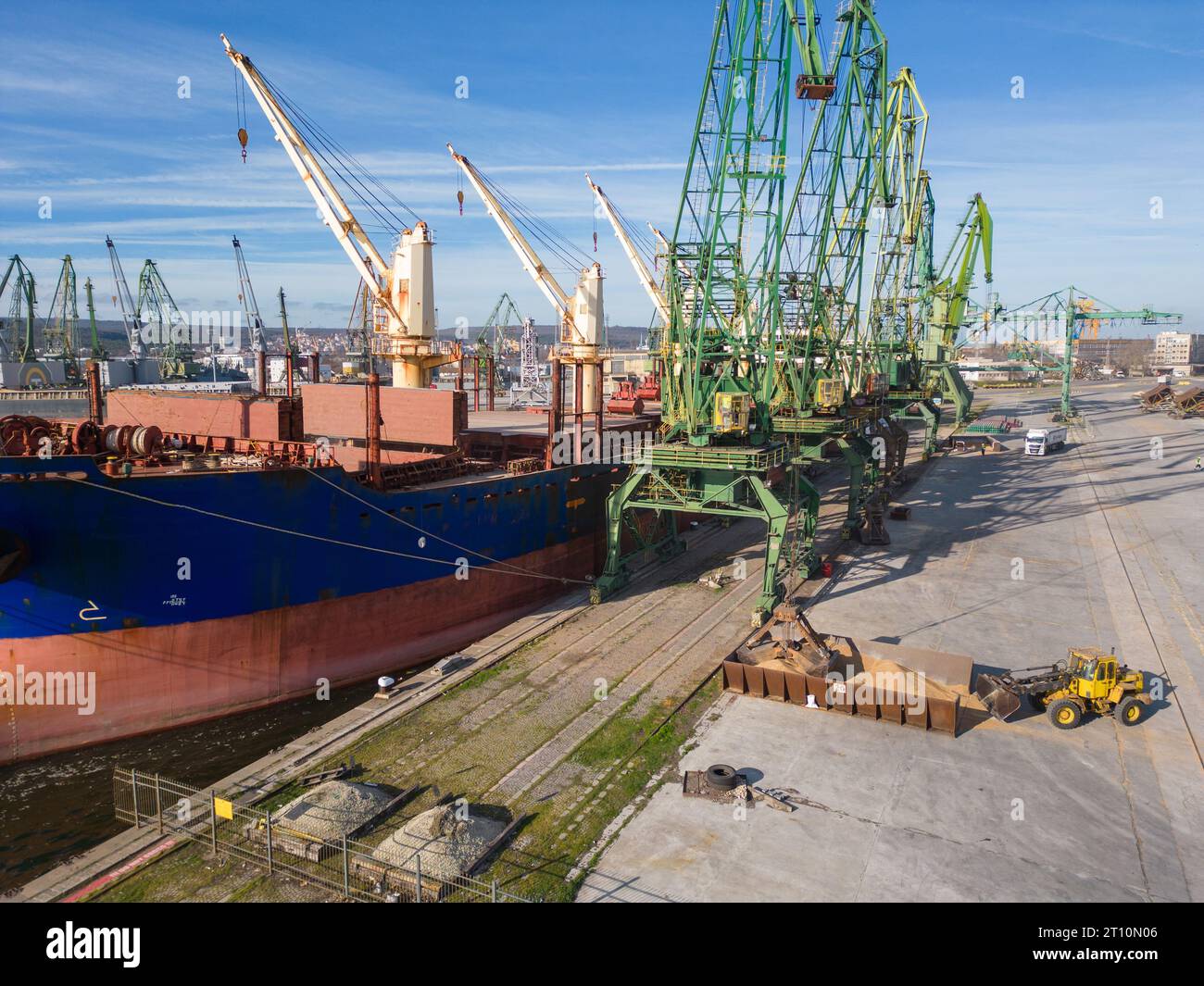A bulk carrier ship loaded or downloaded with grain is docked at a busy ...