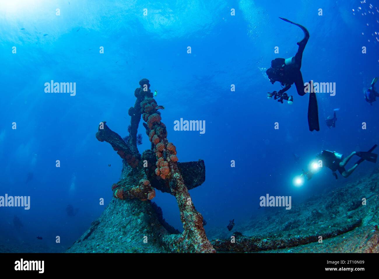 Scuba divers explores propeller of sunken shipwreck dive Stock Photo ...