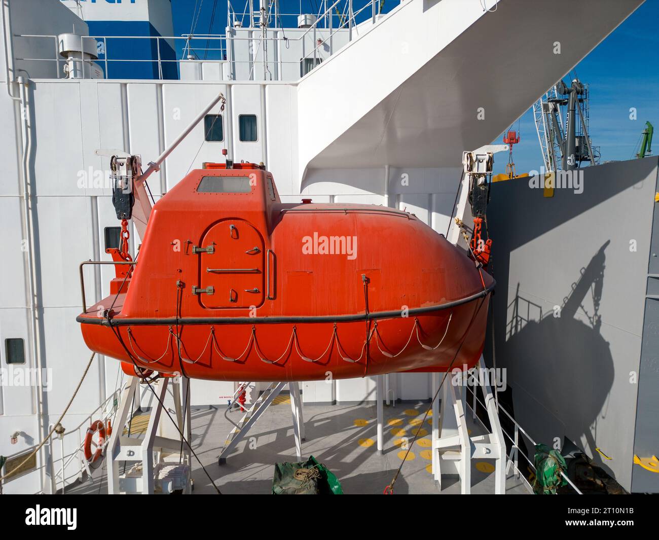 orange lifeboat on a cargo ship, for emergency evacuation. The boat is ...