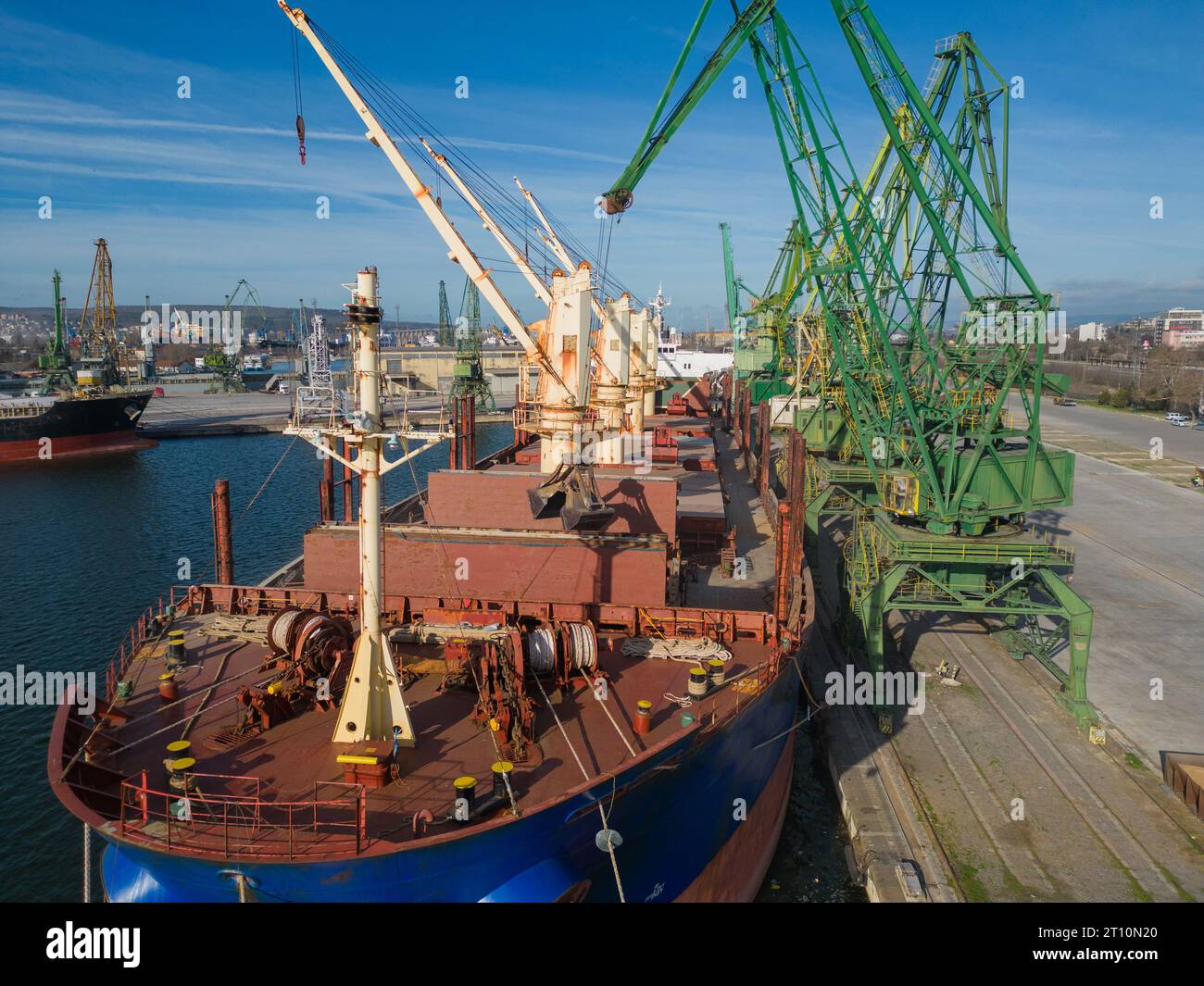 A bulk carrier ship loaded or downloaded with grain is docked at a busy ...