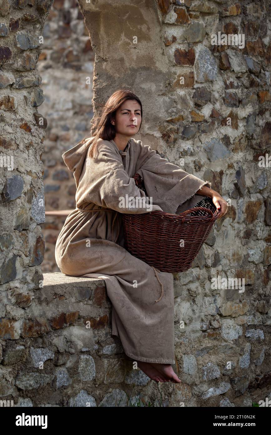 Medieval collector with basket sits in castle Stock Photo - Alamy