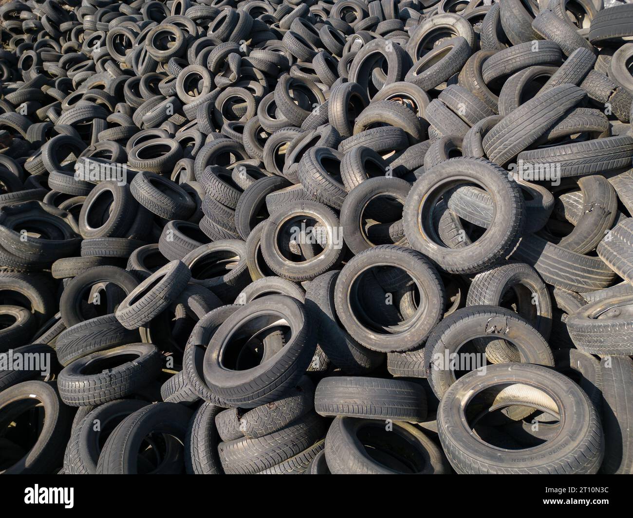 top-down view of a massive dump of car tires. The sea of discarded ...