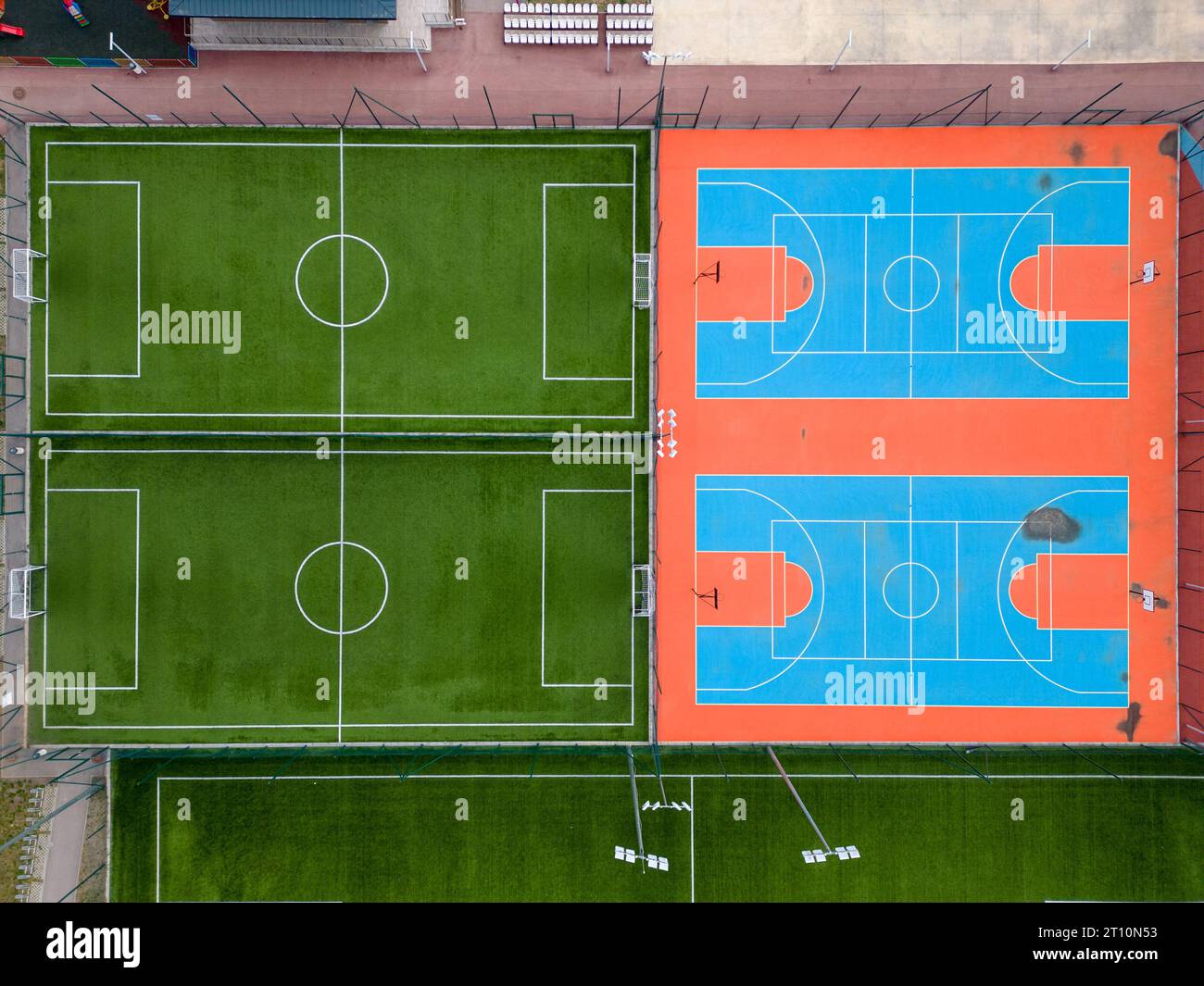aerial view of a green football field and a colorful basketball court ...