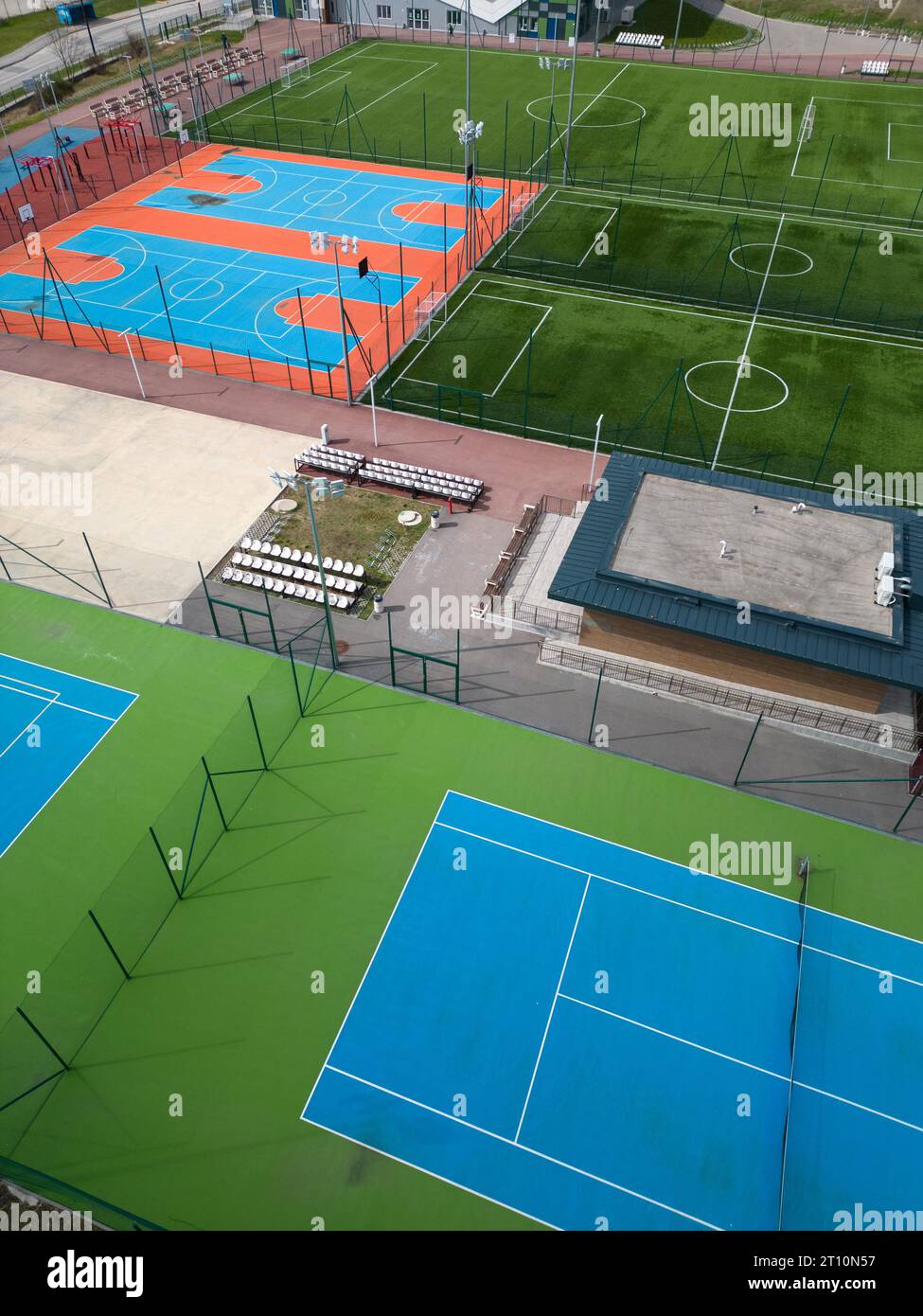 aerial view of a green football field, colorful basketball courts, and ...