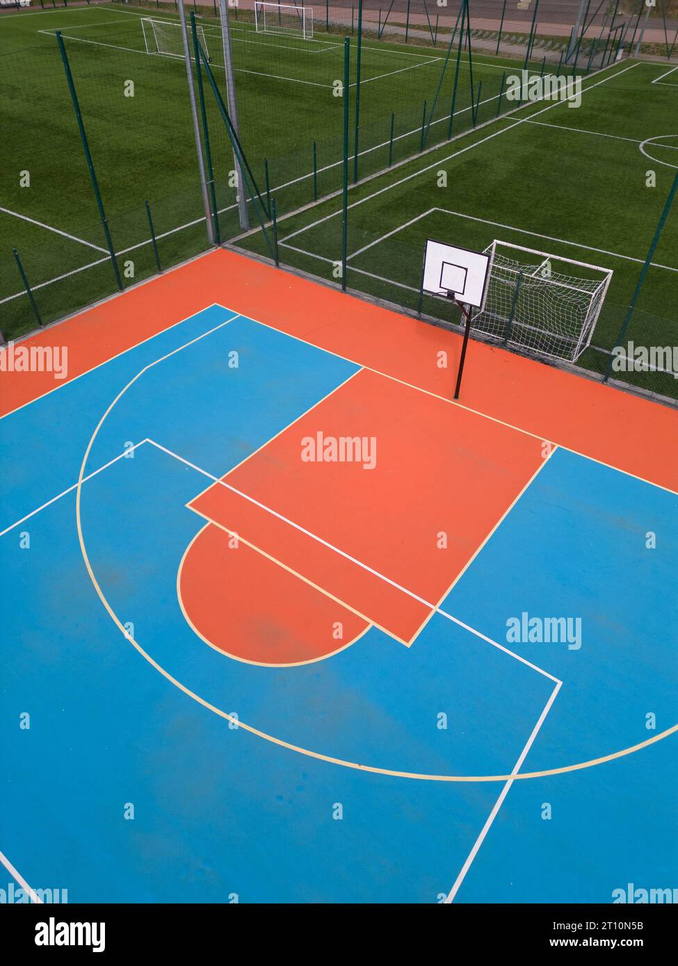 aerial view of a green football field and a colorful basketball court ...