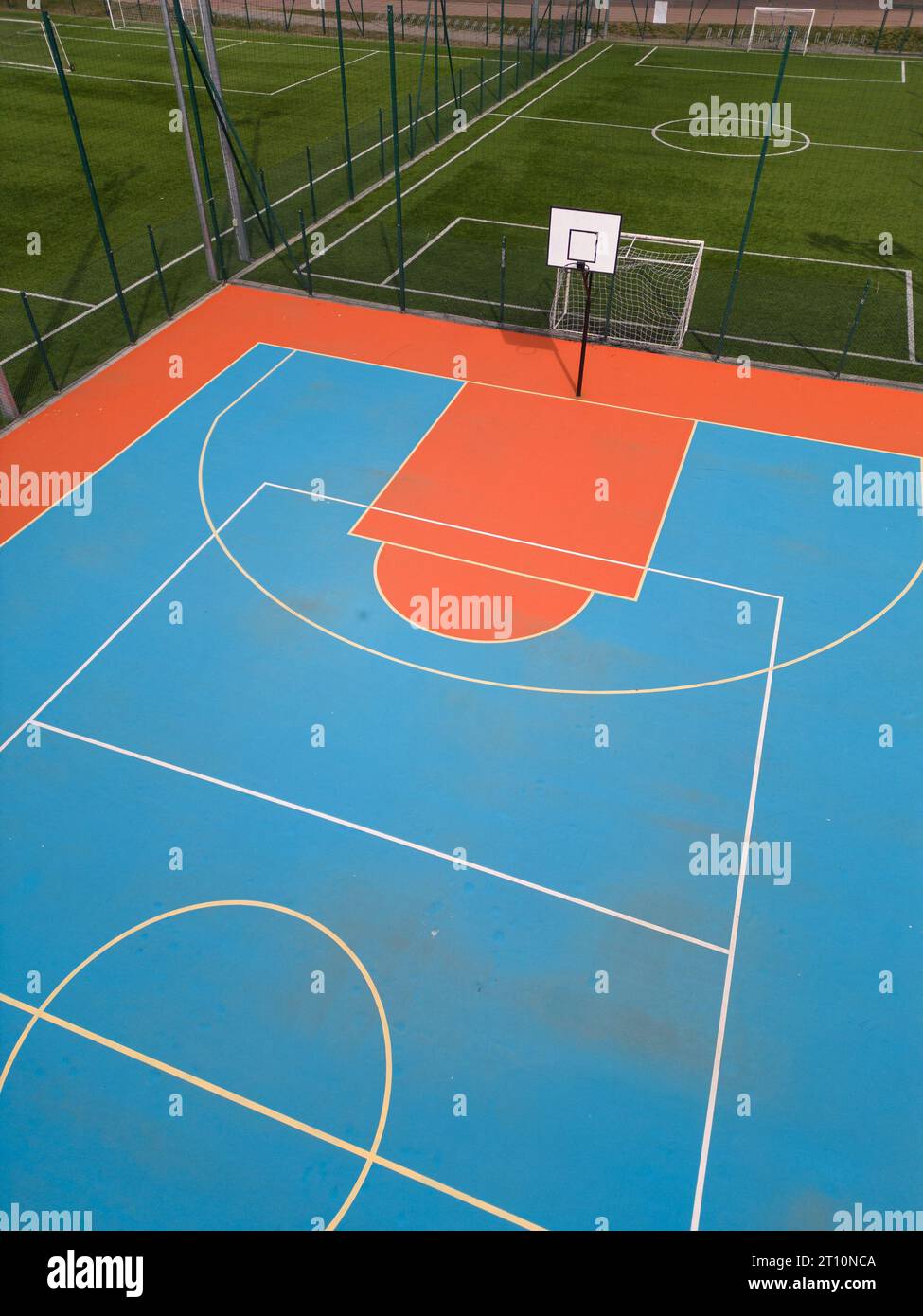 aerial view of a green football field and a colorful basketball court ...