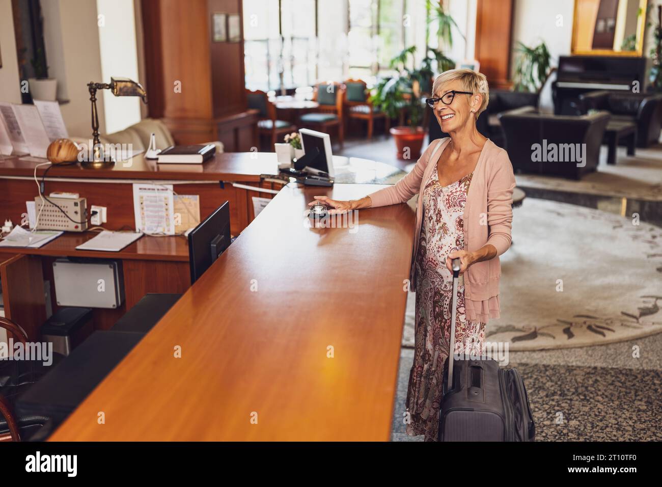 Mature woman comes to the hotel at the reception. She is waiting for ...