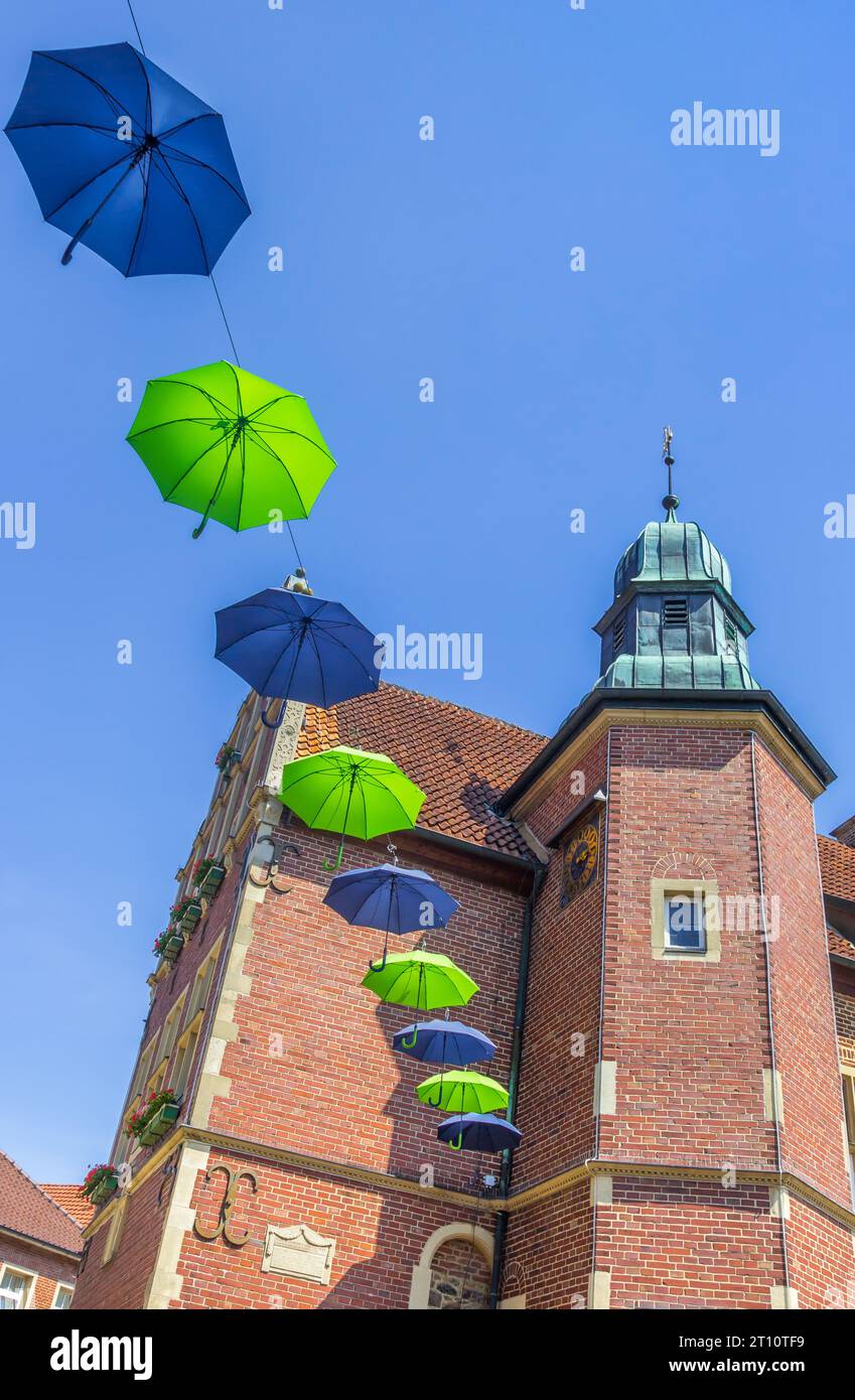 Blue and green umbrellas attached to the historic city hall of Meppen ...