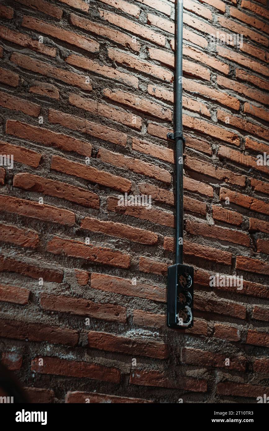 An industrial power strip was installed on the unfinished brick wall ...