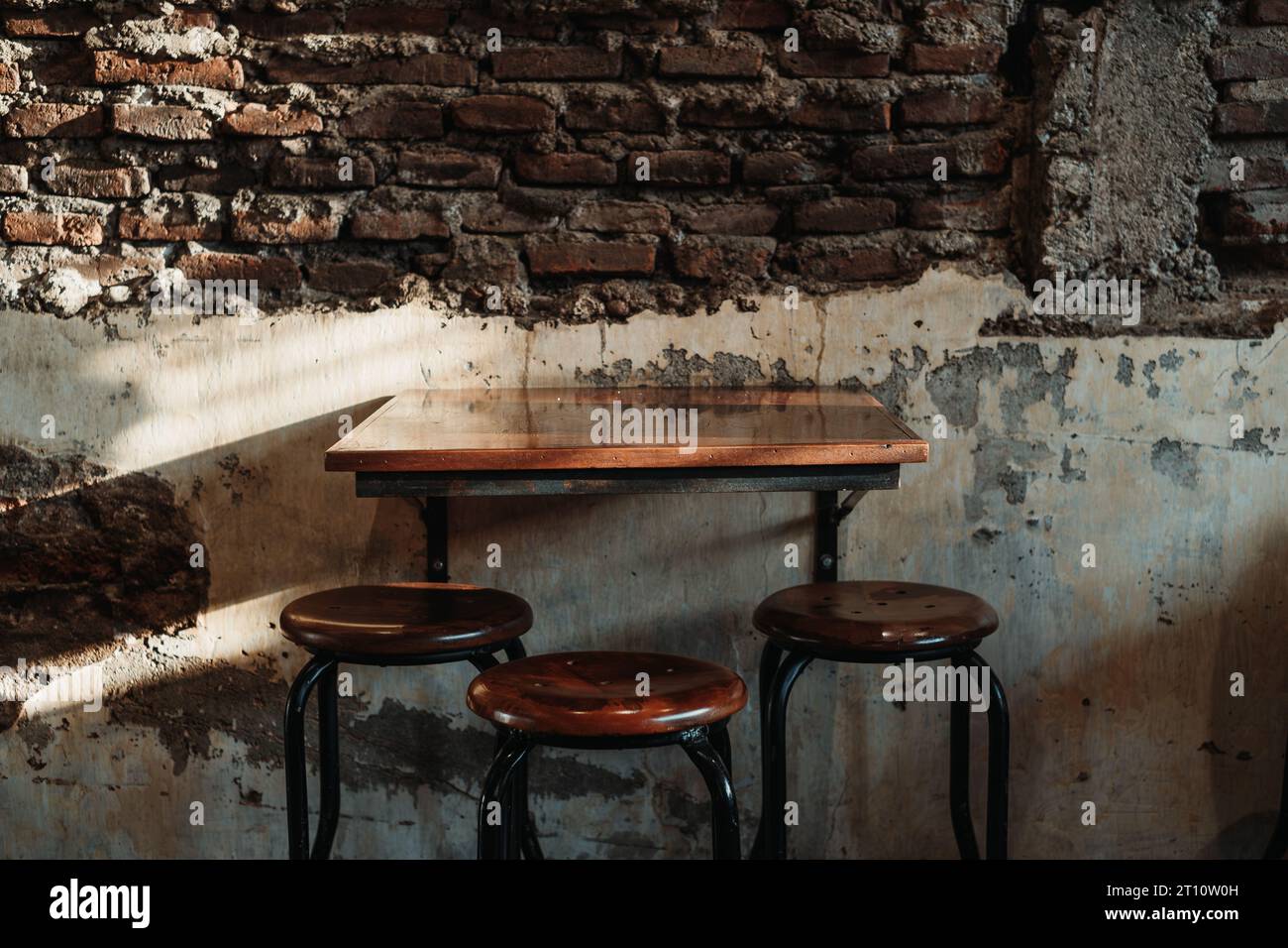 Wooden stool set with unfinished or damaged brick wall. Vintage rustic ...