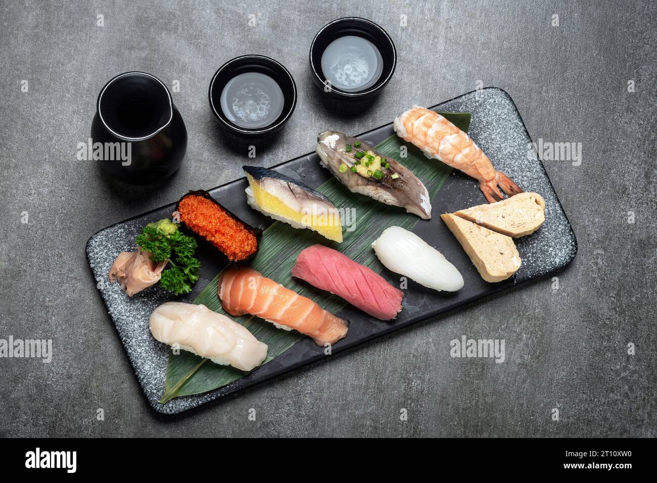 omakase mixed sushi set with sake on grey background in japanese ...