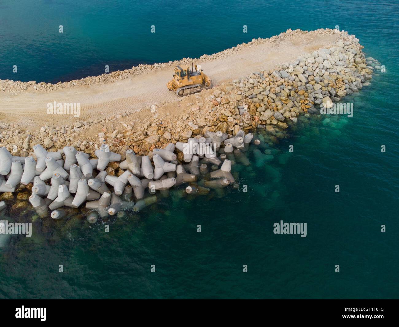 Aerial top view of breakwater construction. Bulldozer on a pile of ...