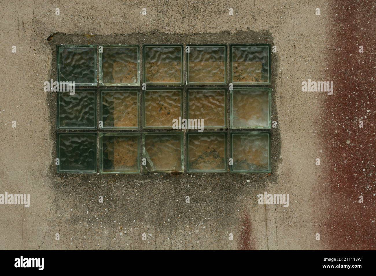 Old wall with glass block window. Translucent square glass tiles. Rough ...