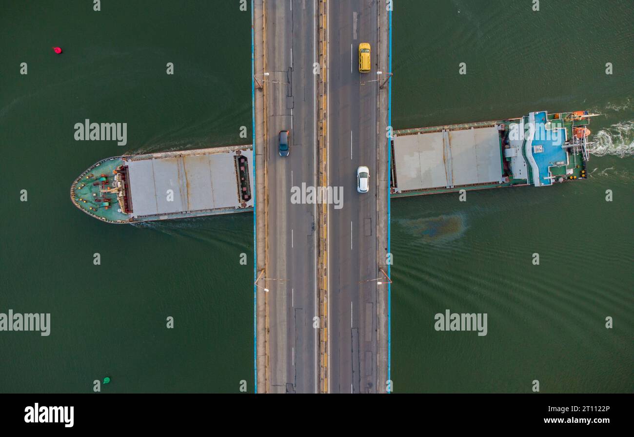 Large general cargo ship tanker bulk carrier passing under a bridge ...
