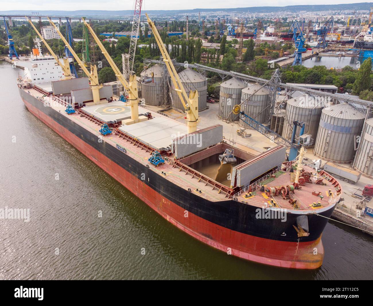 Loading grain into holds of sea cargo vessel in seaport from silos of ...