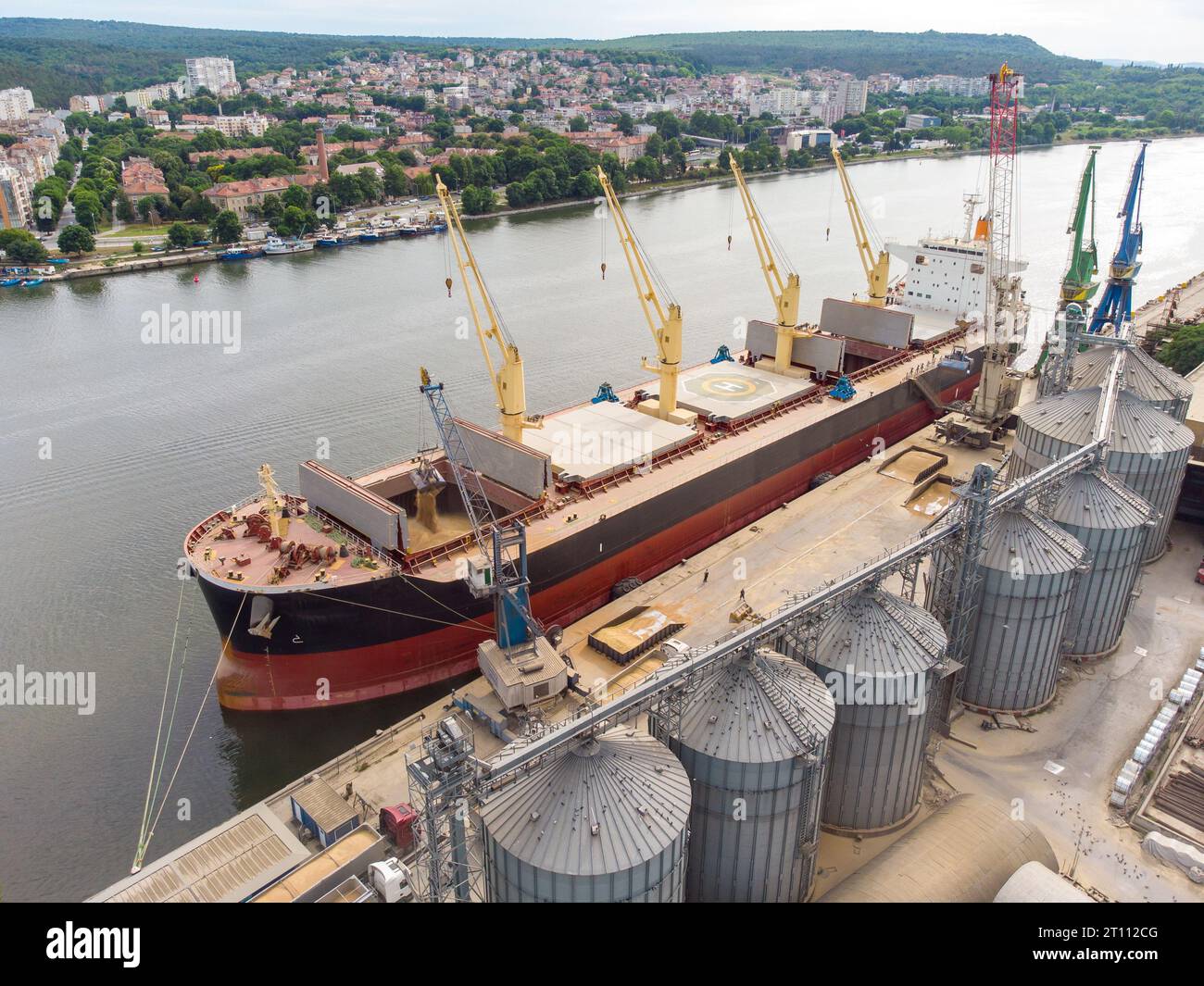 Loading grain into holds of sea cargo vessel in seaport from silos of ...