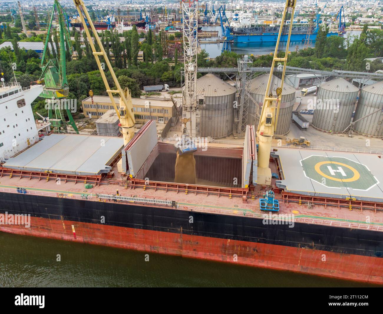 Loading grain into holds of sea cargo vessel in seaport from silos of ...