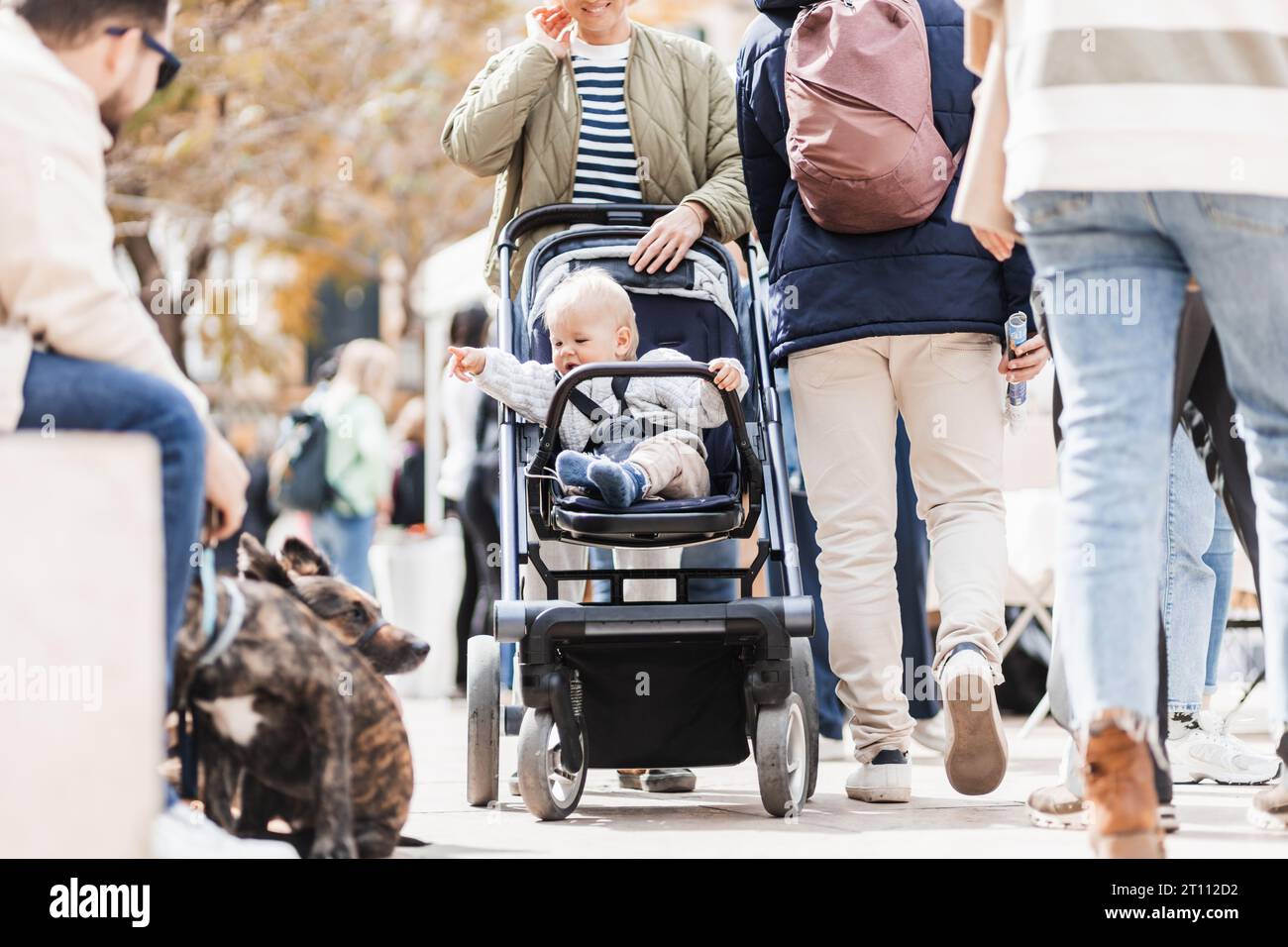 Mother walking and pushing his infant baby boy child in stroller in ...