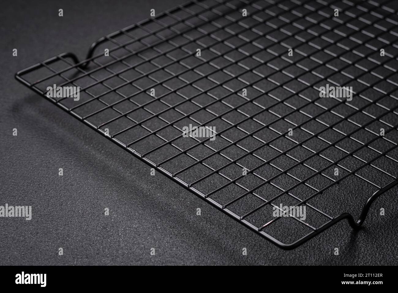 Empty black metal kitchen grate for pouring desserts on dark concrete ...