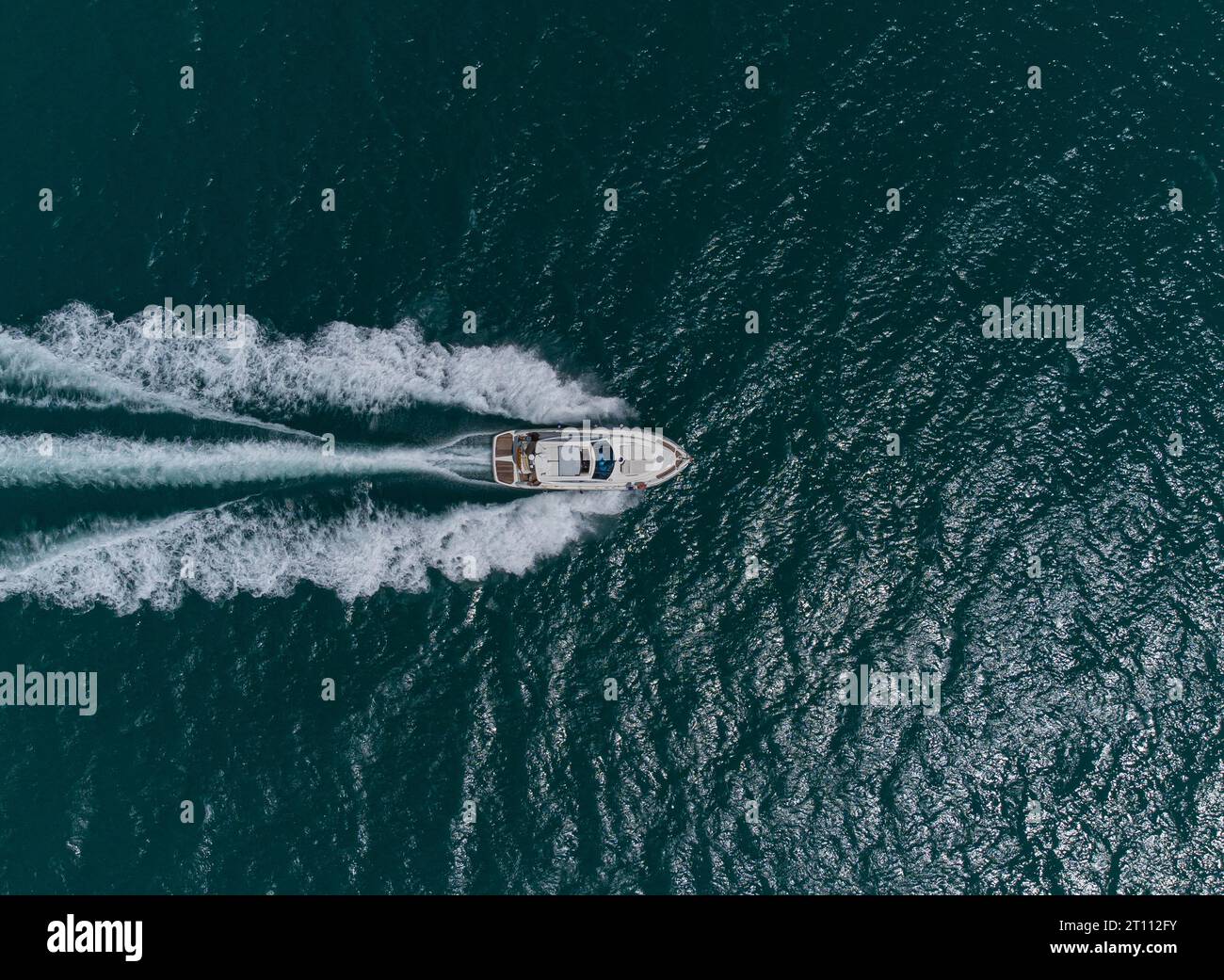 Aerial top down view of white speed motor boat on open sea at summer ...