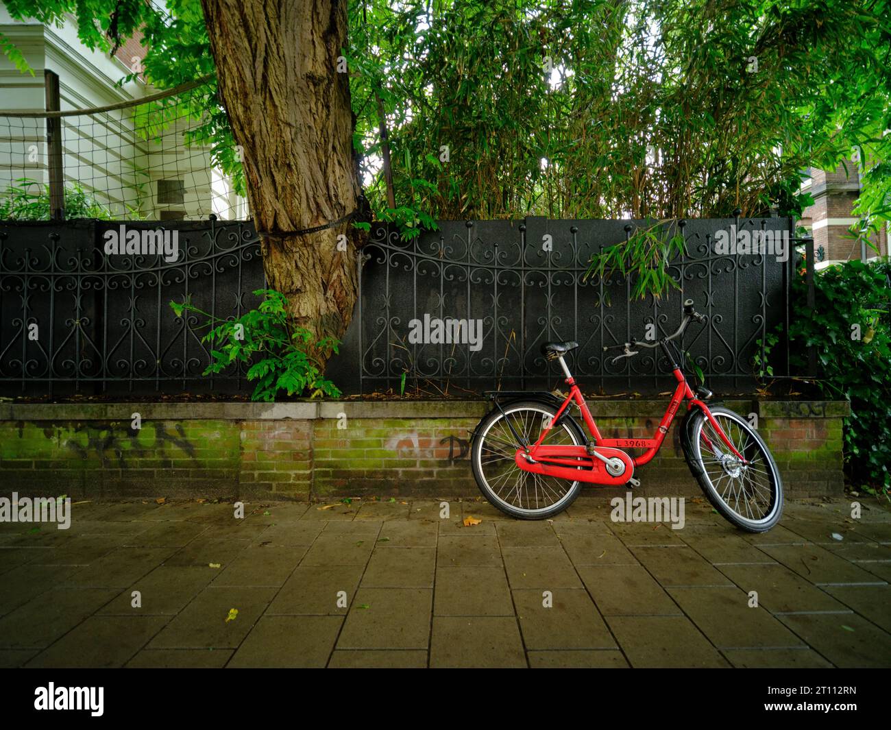 A red bike leans against a wall in Amsterdam Stock Photo - Alamy