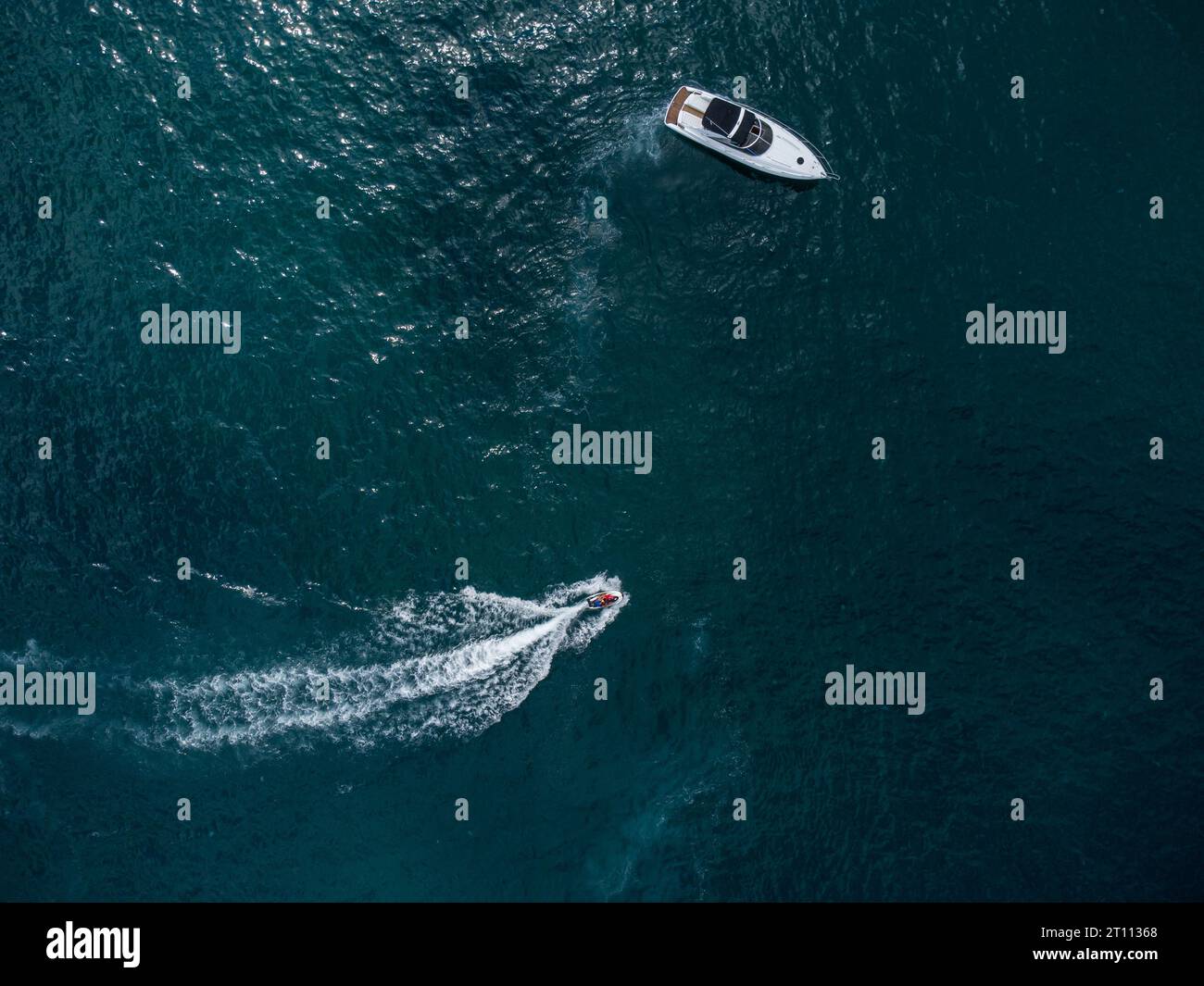 Aerial top down view of speed motor boat and floating scooter on open ...