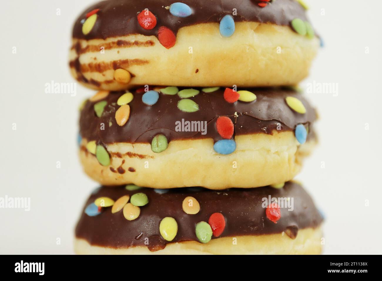 A stack of doughnuts glazed with chocolate and colorful smarties. Pile ...