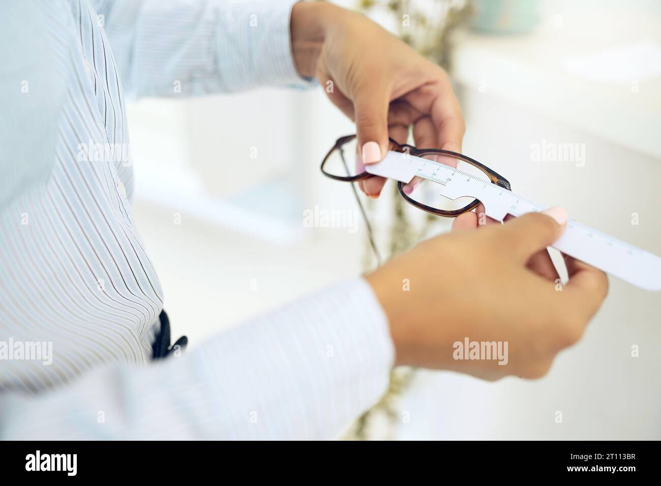 Hands, measure lens and frame of glasses, person in optometry clinic ...