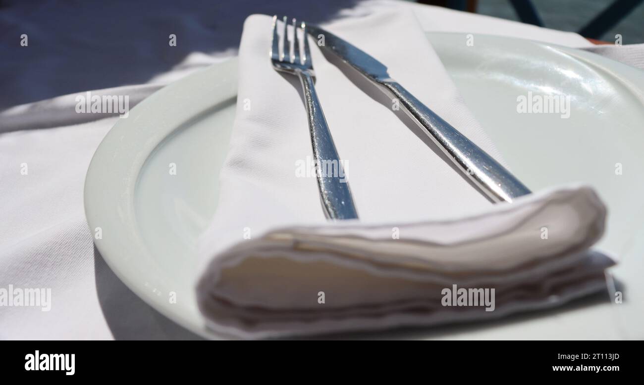 Table setting with white ceramic plate and white table cloth. Dining ...