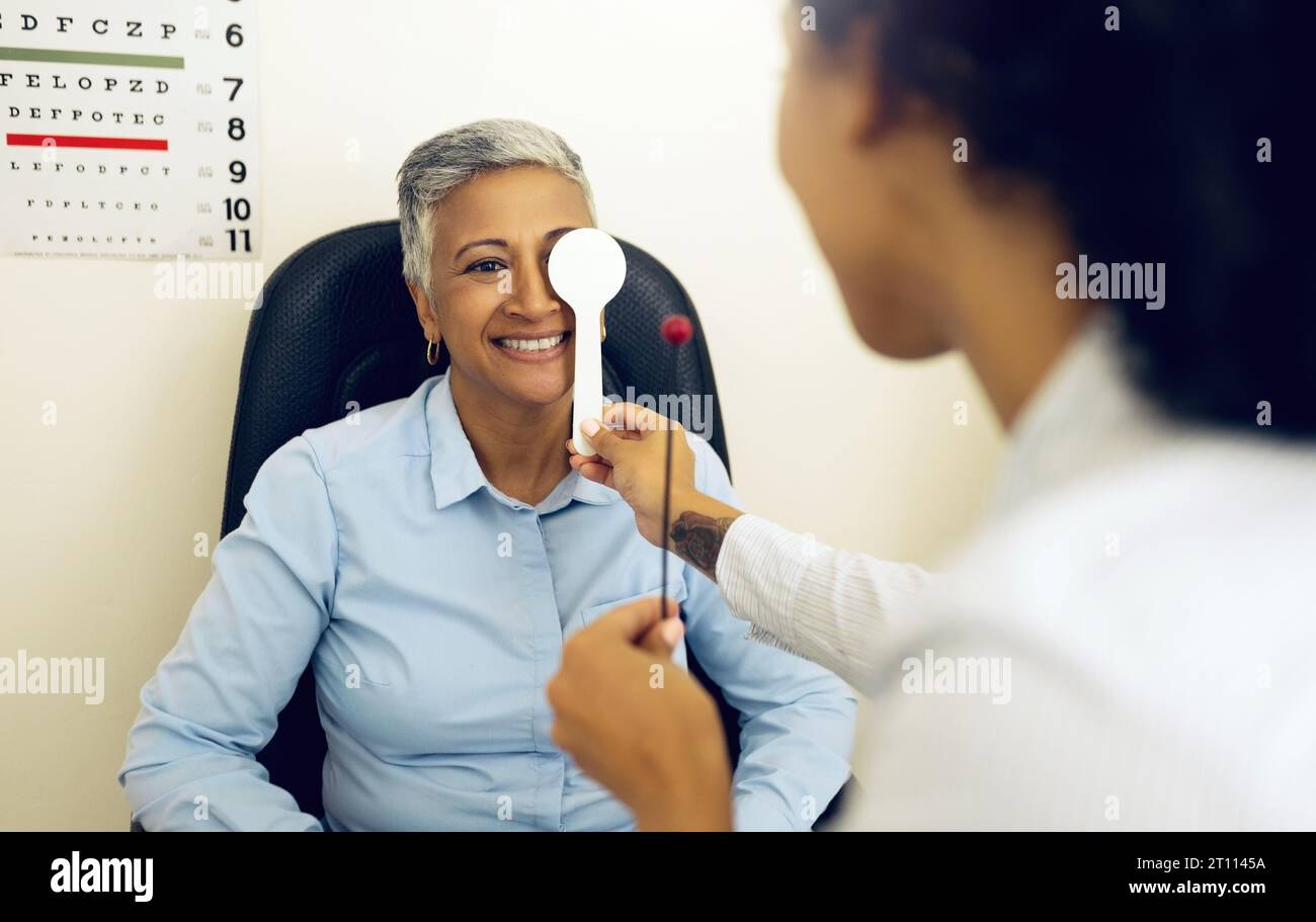 Eye exam, woman and optometrist with cover for vision, healthcare and ...