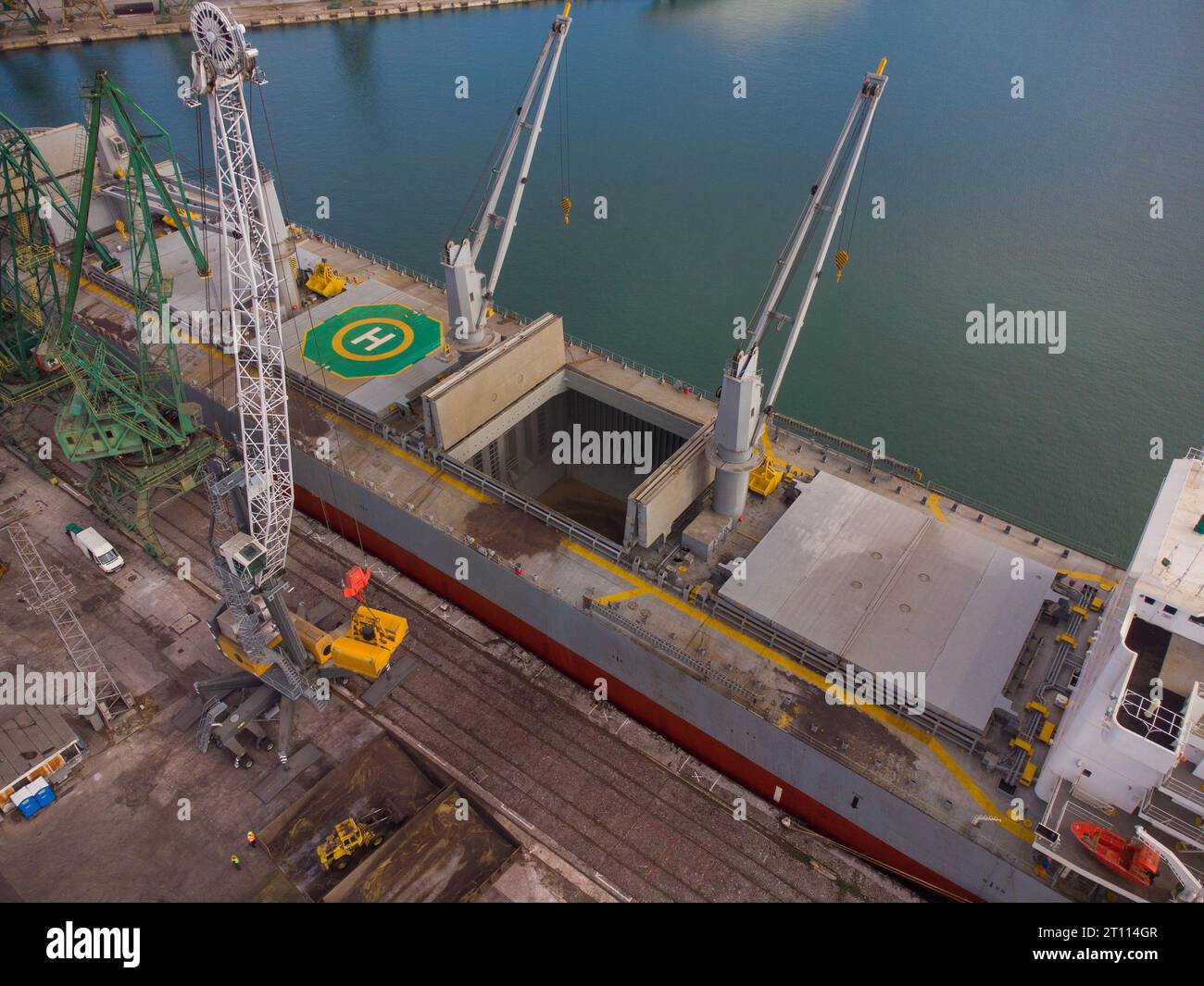 Aerial top view of big cargo ship bulk carrier is loaded with coal in ...