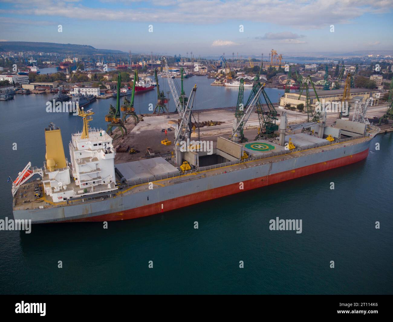 Aerial top view of big cargo ship bulk carrier is loaded with coal in ...