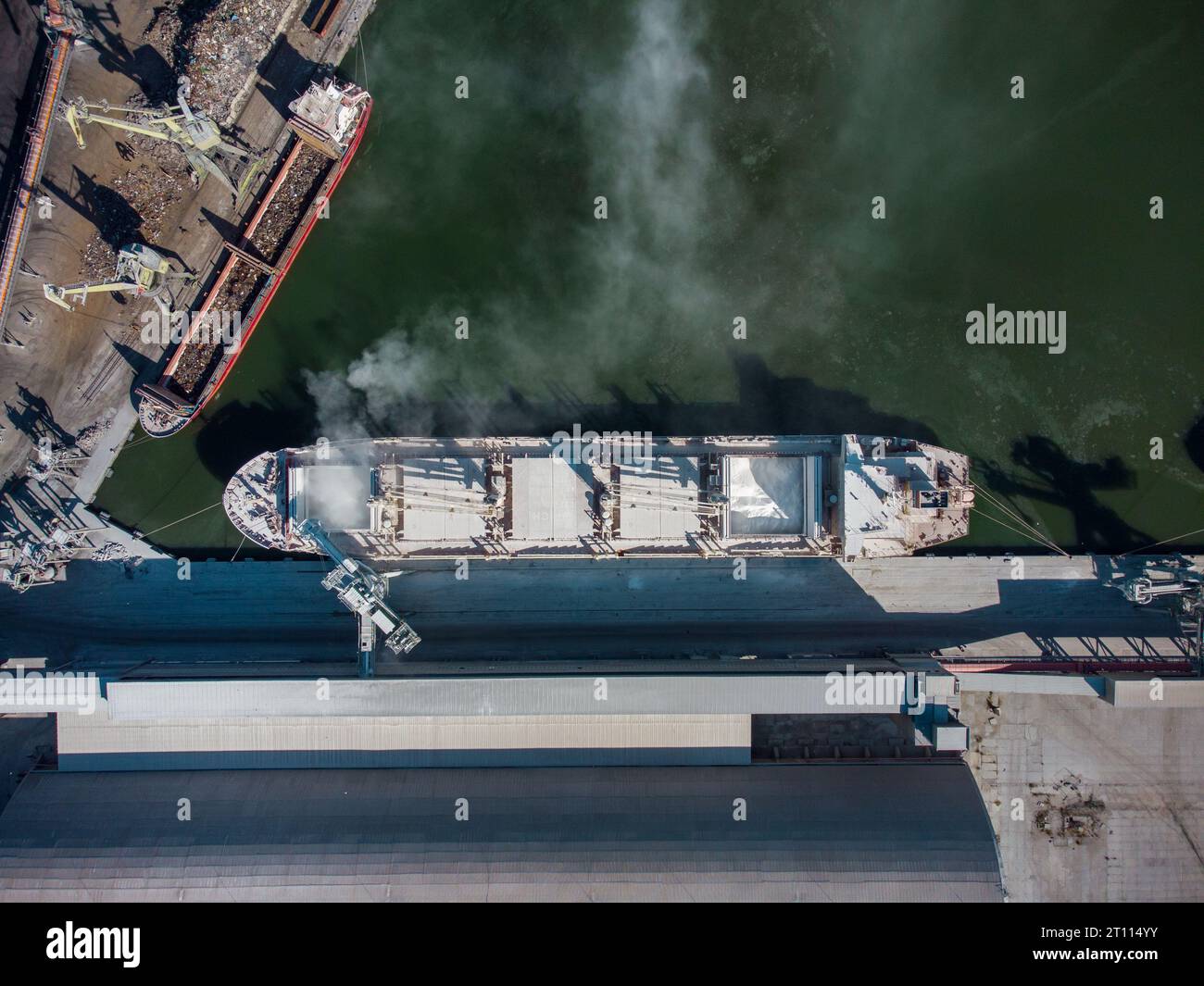 Aerial top view of big cargo ship bulk carrier is loaded with minerals ...