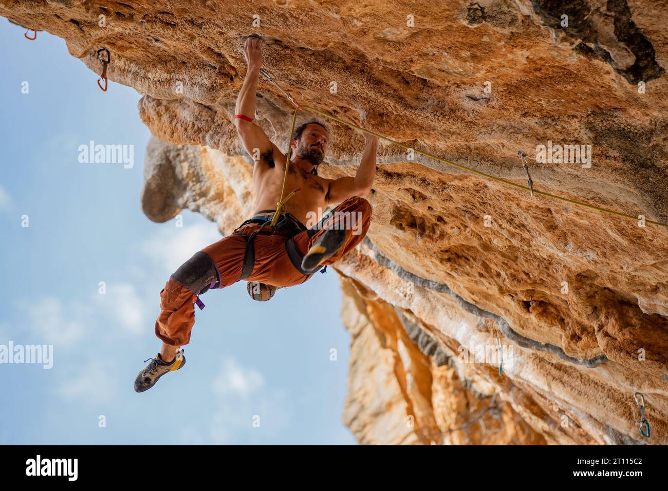 A climber cuts his feet in dynamic movement on the steep limestone ...