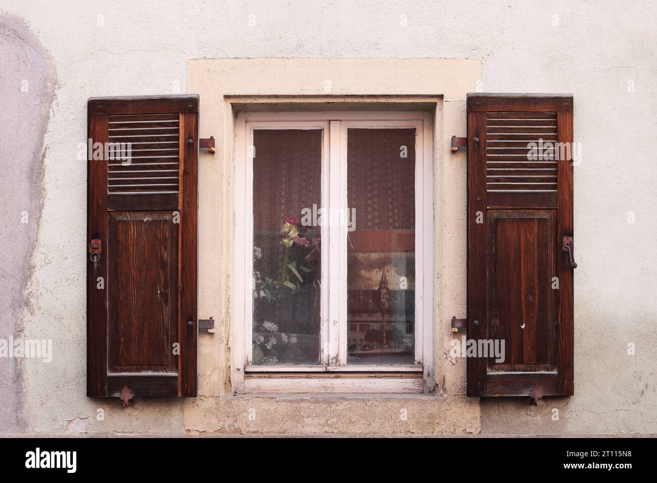 Country style window with old dried flowers, retro wooden shutters, an ...