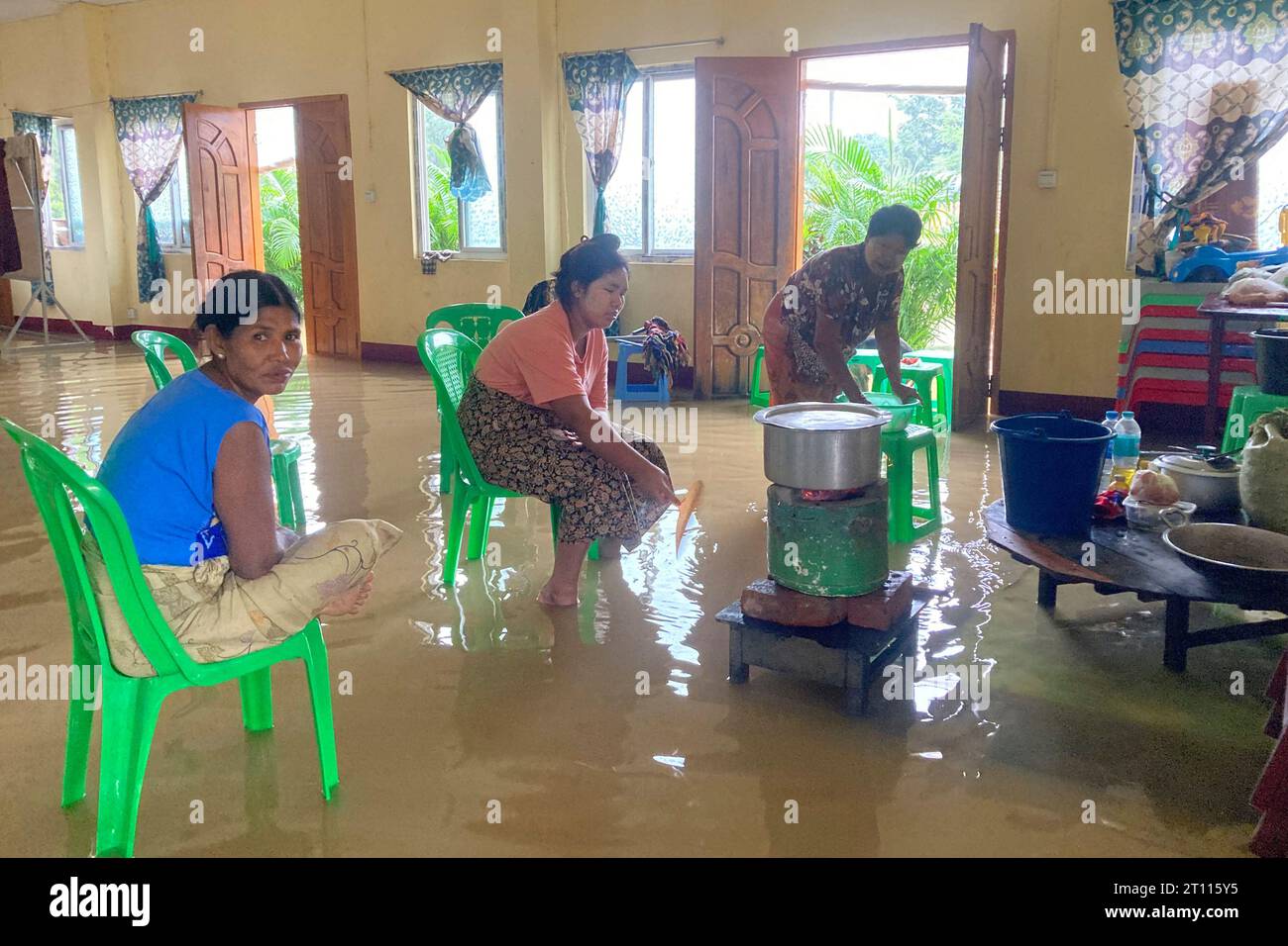 Flood victims cook meals inside a monastery opened for a temporary ...