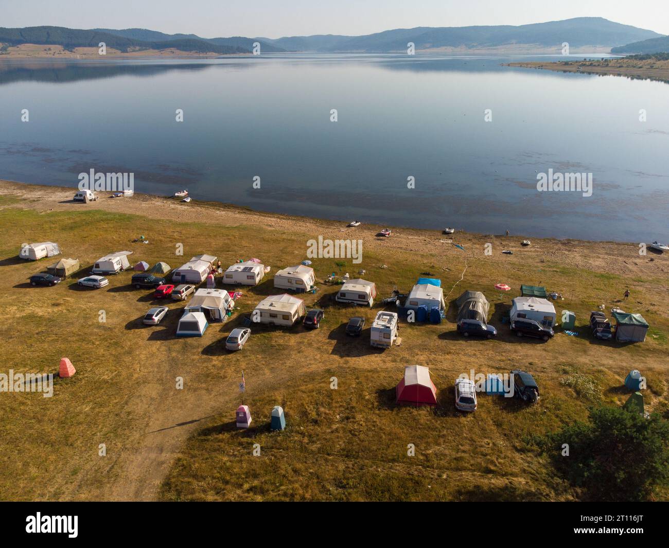 Aerial top view of a campers van parked on a beach, mountain range ...