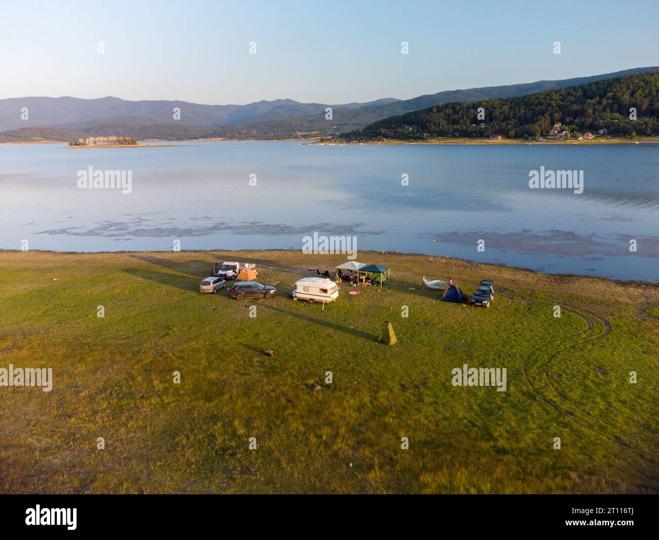 Aerial top view of a campers van parked on a beach, mountain range ...