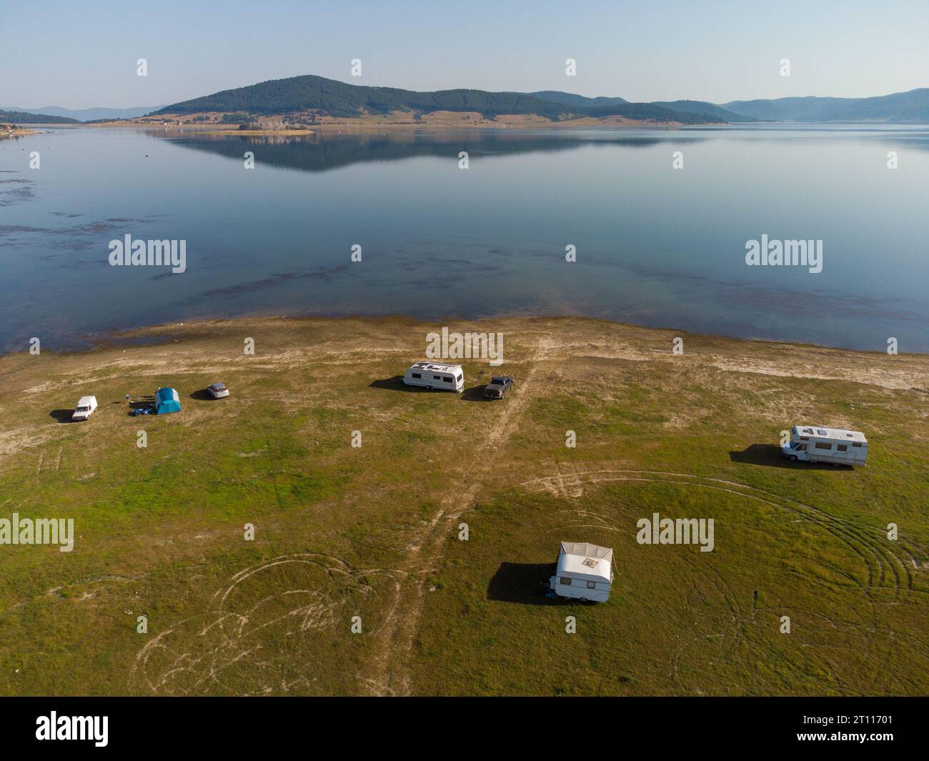 Aerial top view of a campers van parked on a beach, mountain range ...