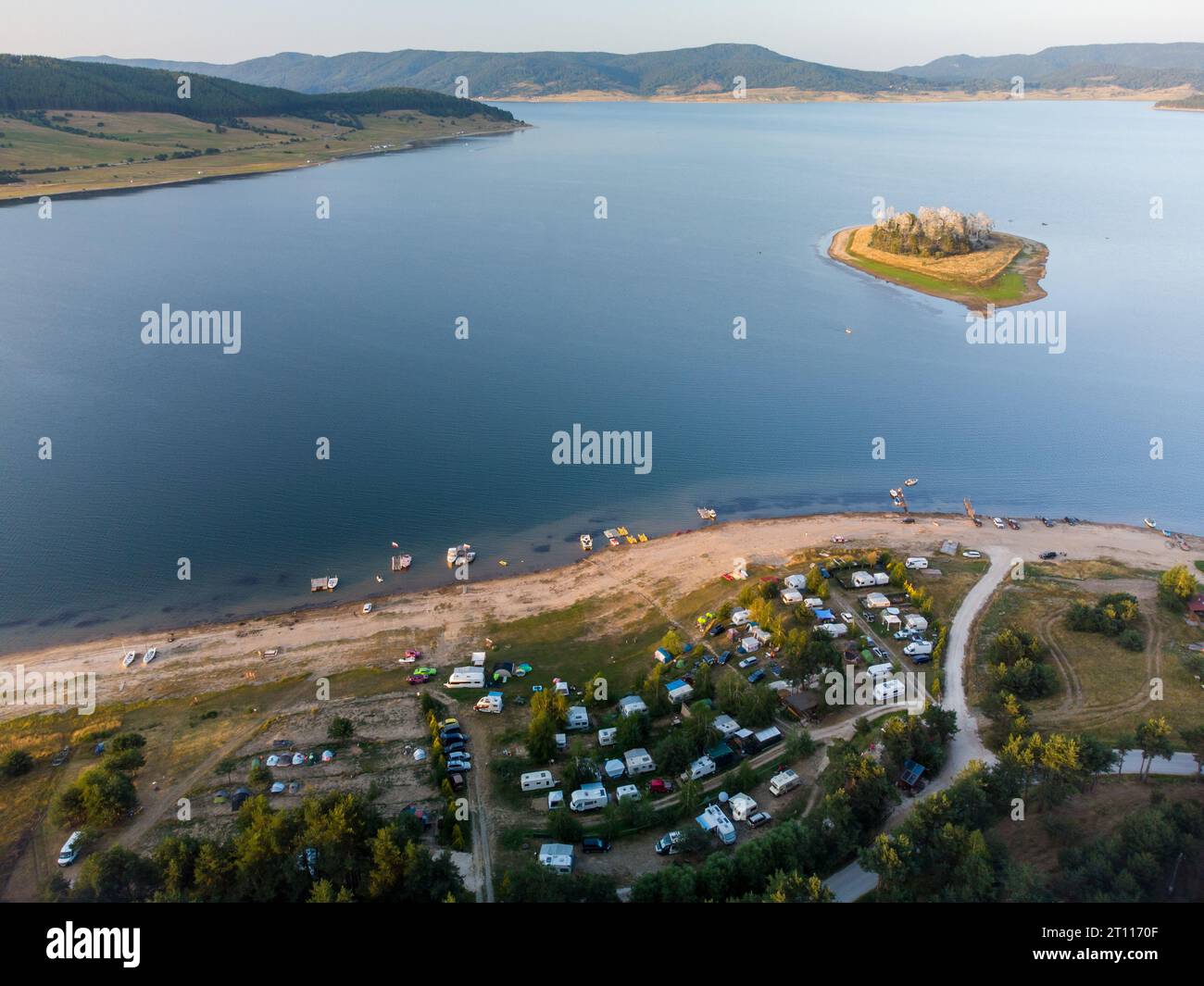 Aerial top view of a campers van parked on a beach, mountain range ...