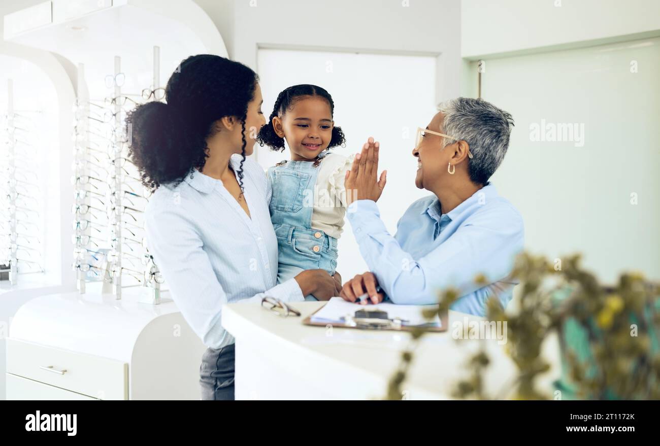 High five, optometrist or girl child with woman for vision, medical ...