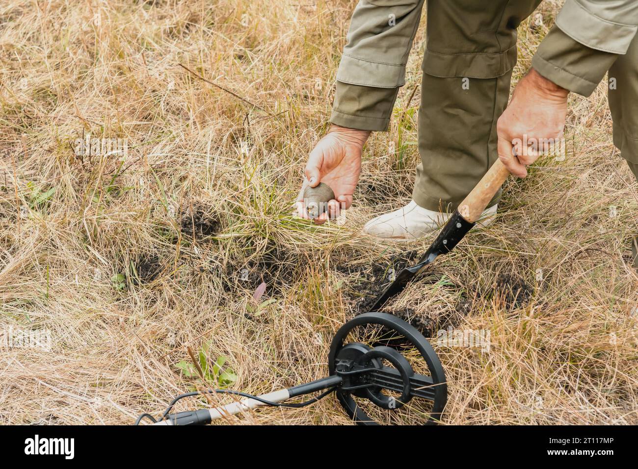 Man with electronic metal detector device working on outdoors. Close-up ...
